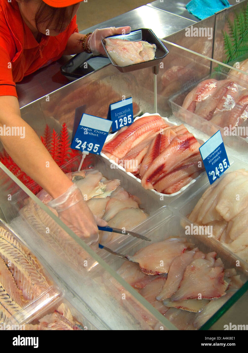 Serving fresh fish fillets at the fishmonger Stock Photo - Alamy