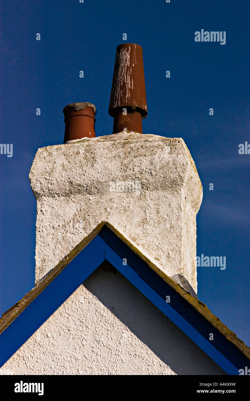White painted chimney and blue boarding against a blue sky Dorset ...