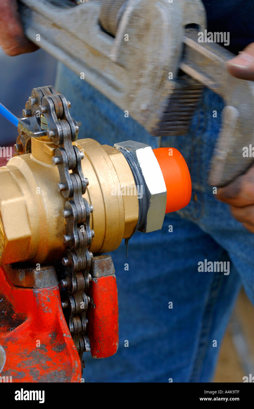 Worker fixing object with wrench Stock Photo - Alamy