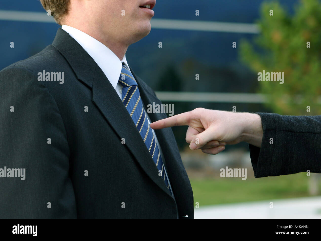 Business man is getting pointed in the chest by another businessman in ...