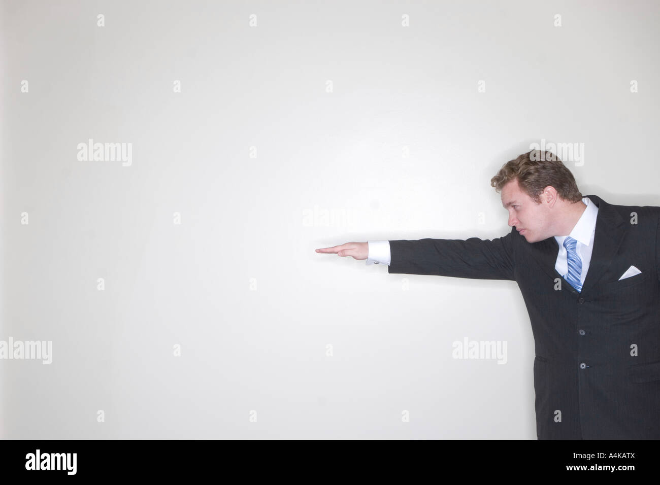 Businessman stands with his arm outstretched giving a mark with the ...