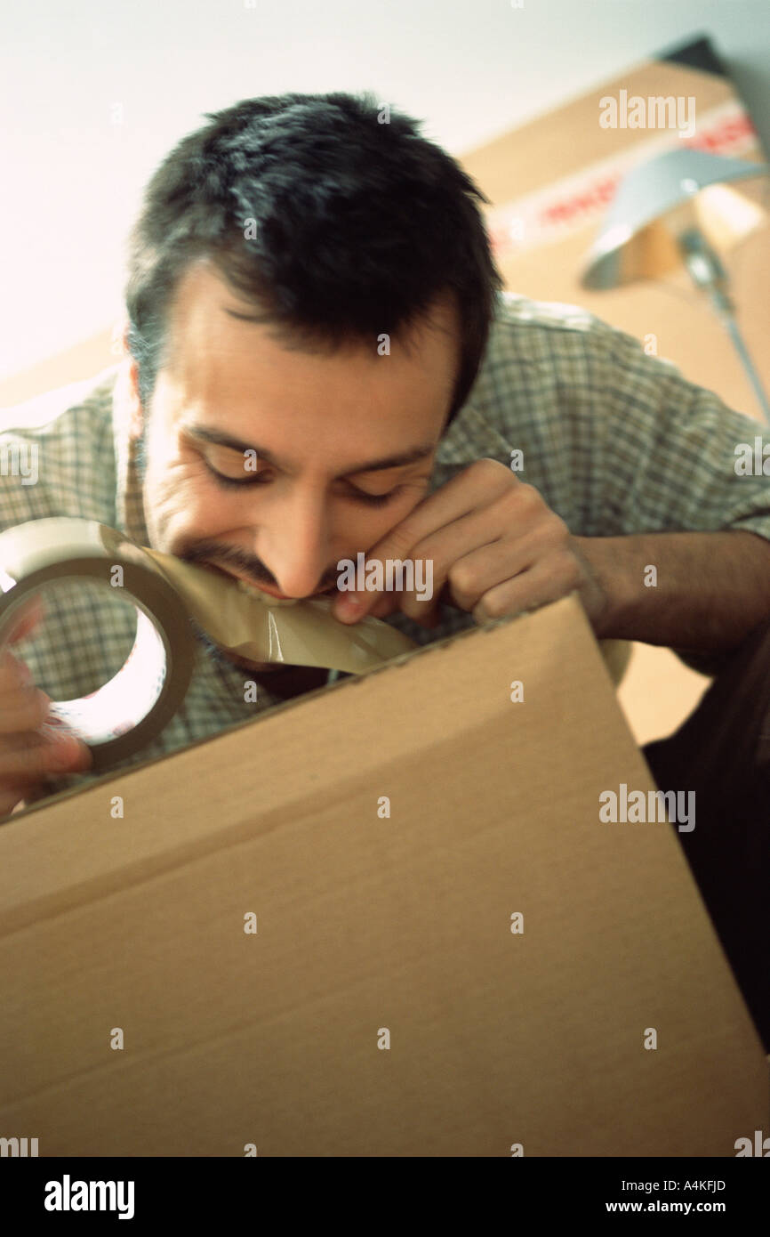 Man tearing tape with teeth Stock Photo - Alamy