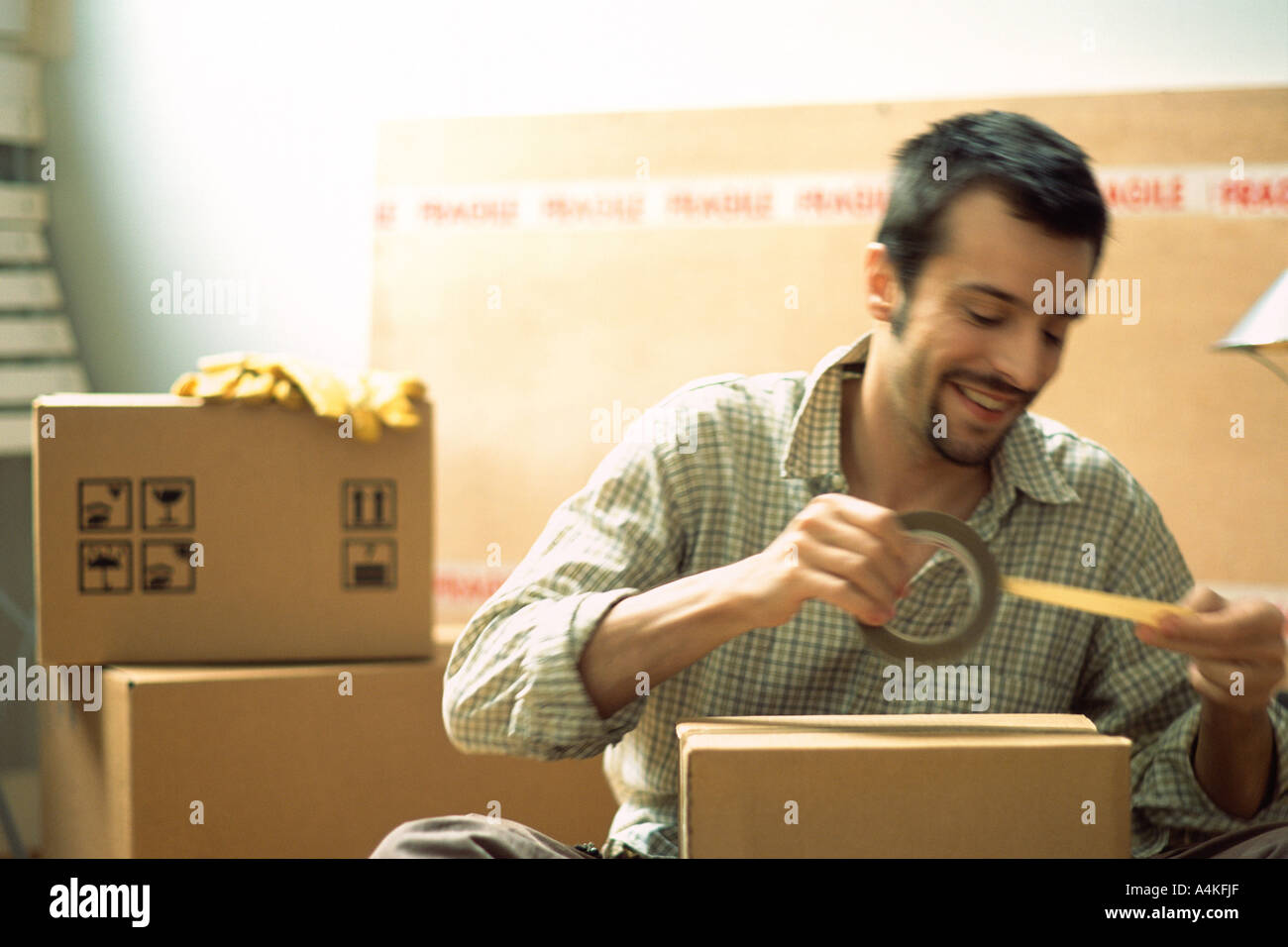 Man closing box with tape Stock Photo - Alamy