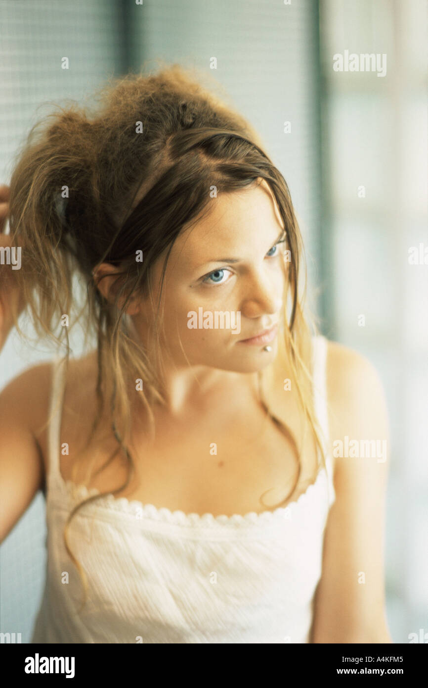 Young woman fixing hair, close-up Stock Photo - Alamy
