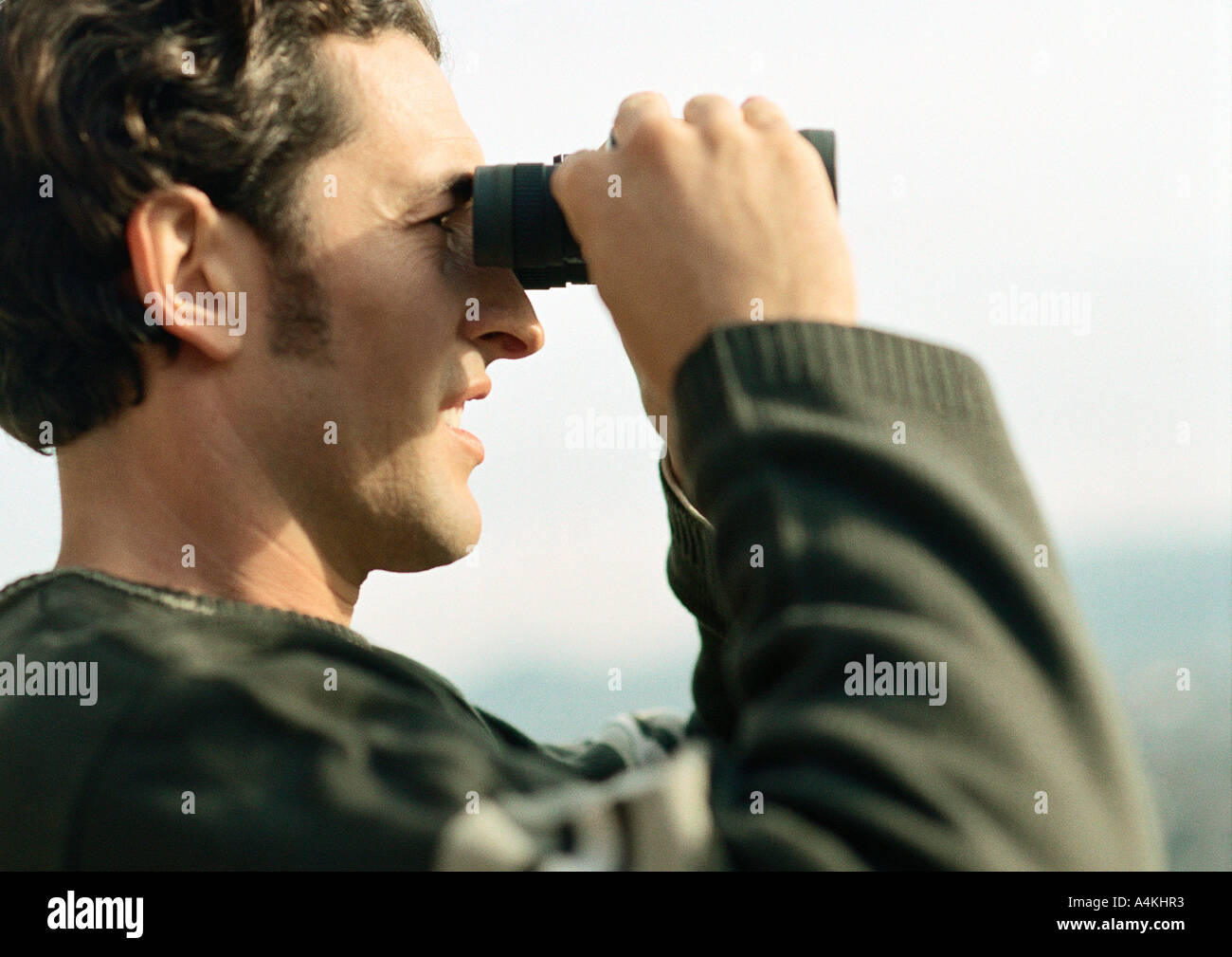 Man looking through binoculars, close-up, side view Stock Photo - Alamy