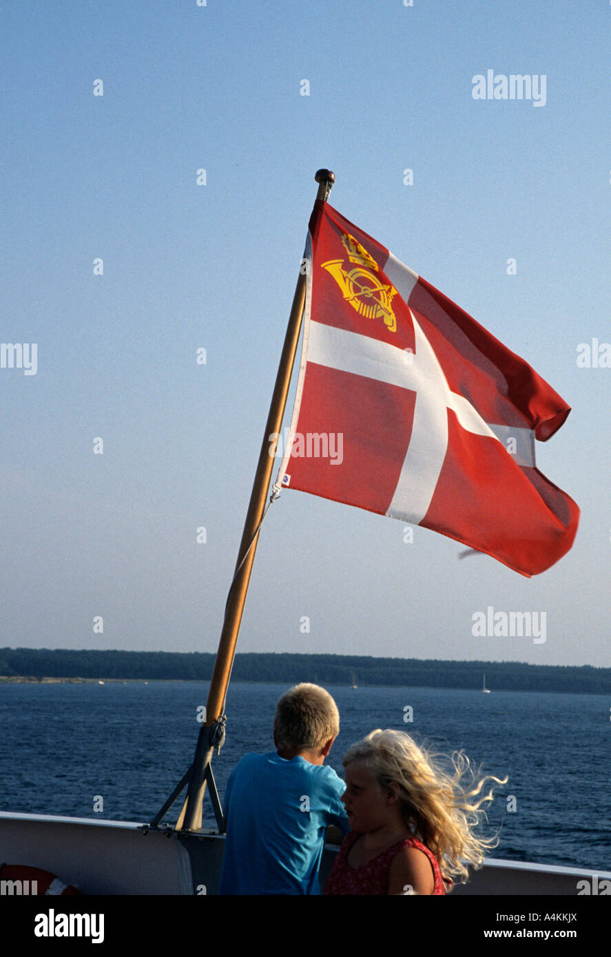 Children and the Danish flag ensign on a ferry from the island of r to ...