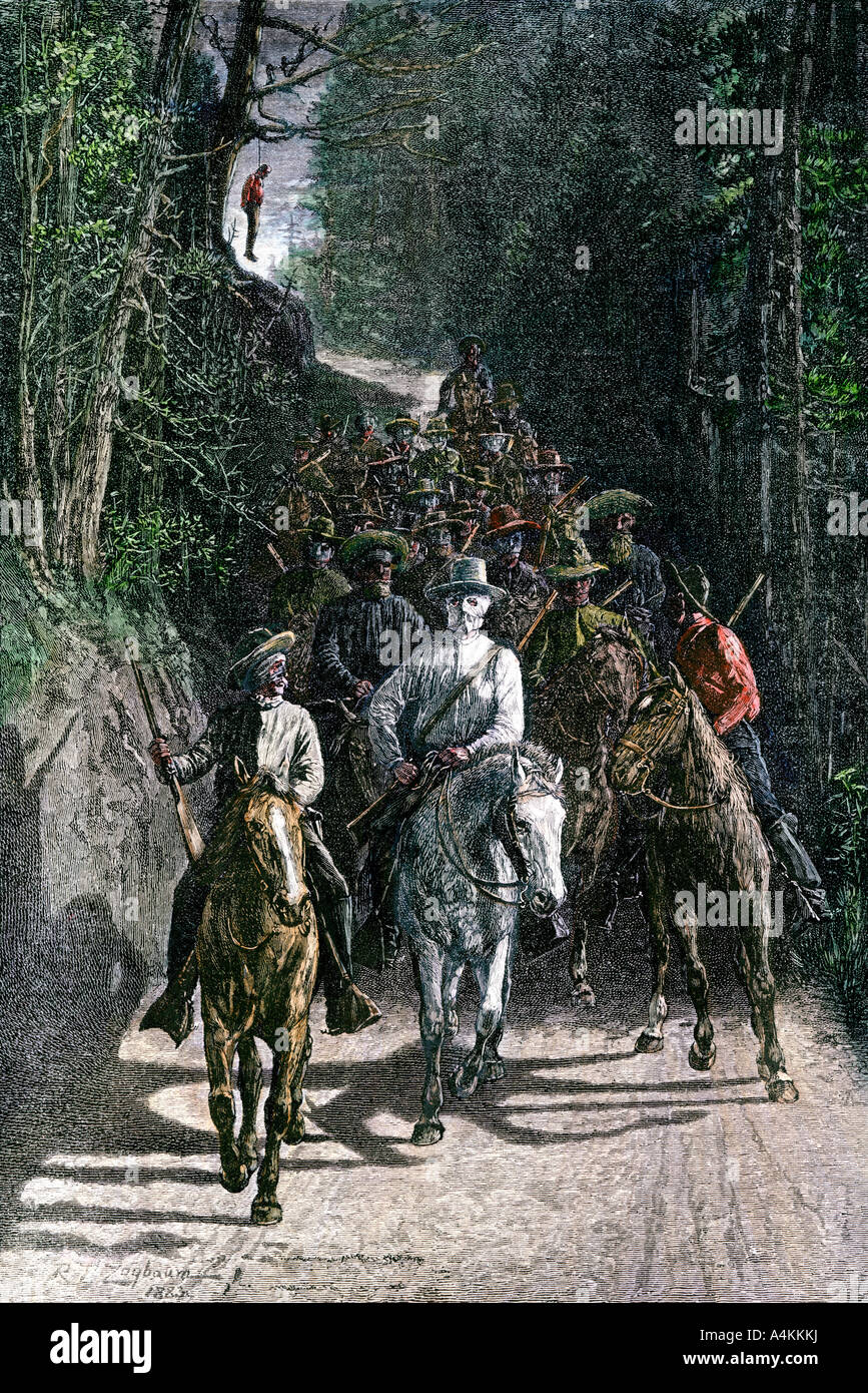 Mob of night riders carrying out a lynching 1800s. Hand-colored woodcut ...