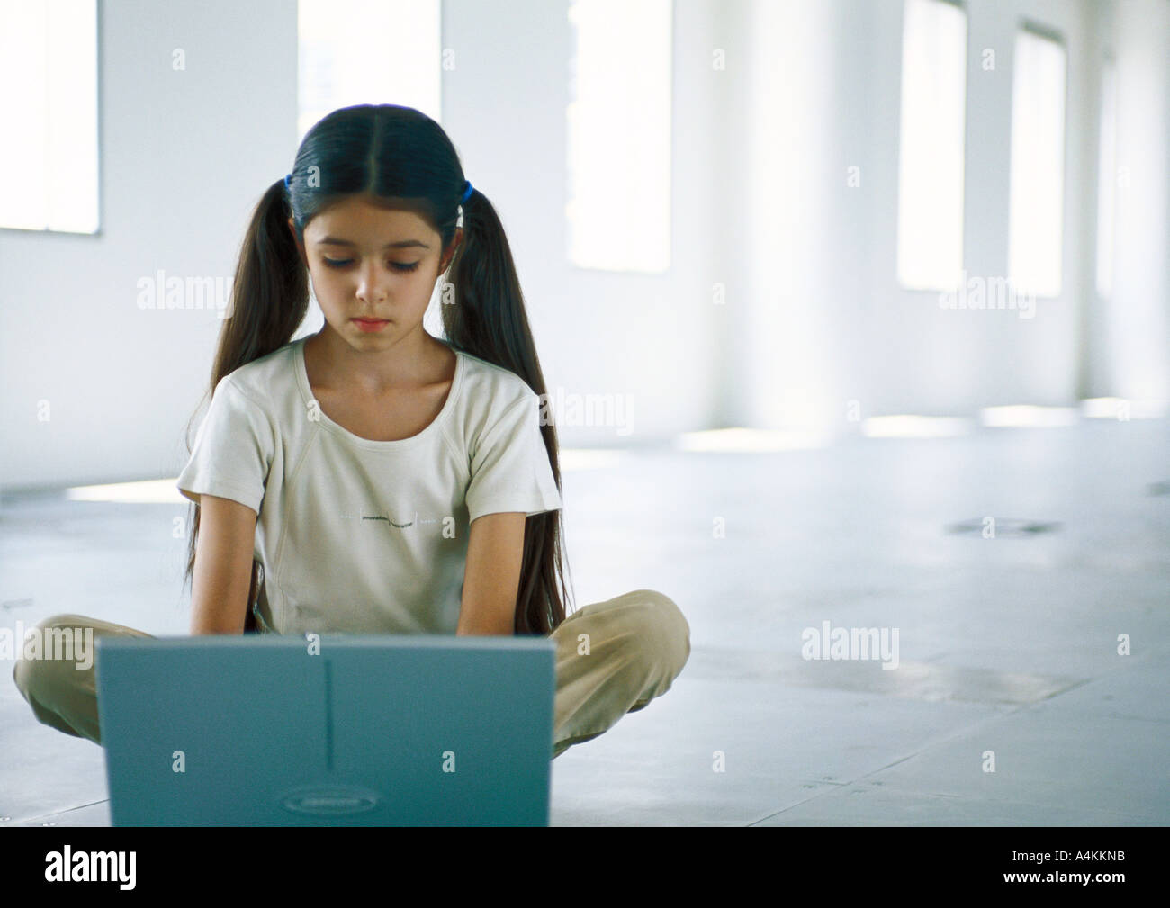 Girl sitting indian style on floor, working on laptop Stock Photo - Alamy