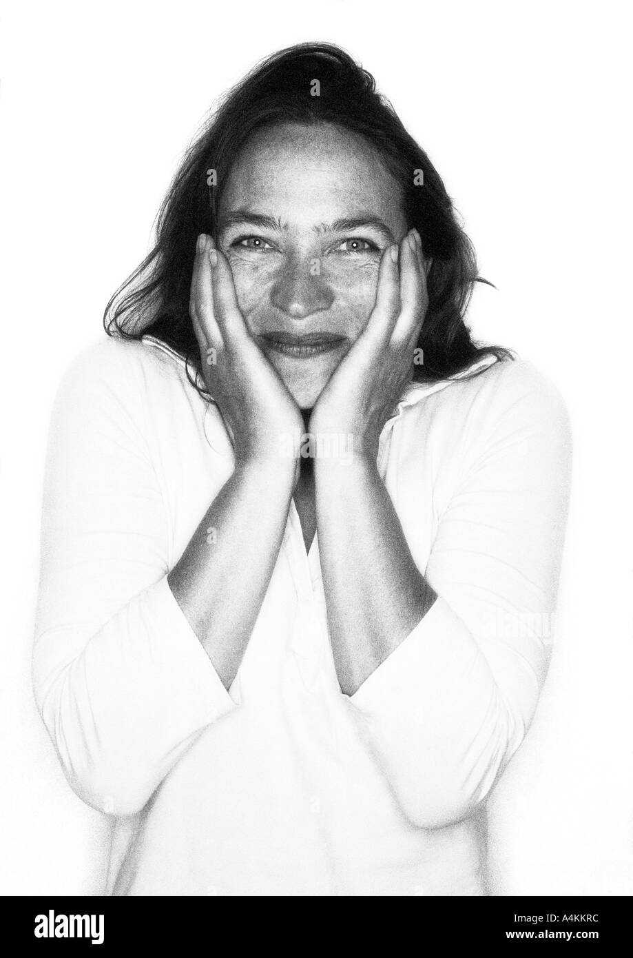 Woman smiling at camera, hands on cheeks, portrait Stock Photo - Alamy