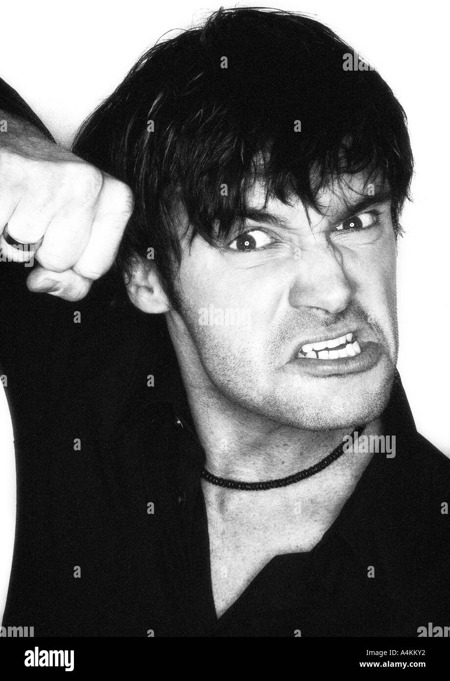Man snarling at camera, fist raised, portrait Stock Photo - Alamy