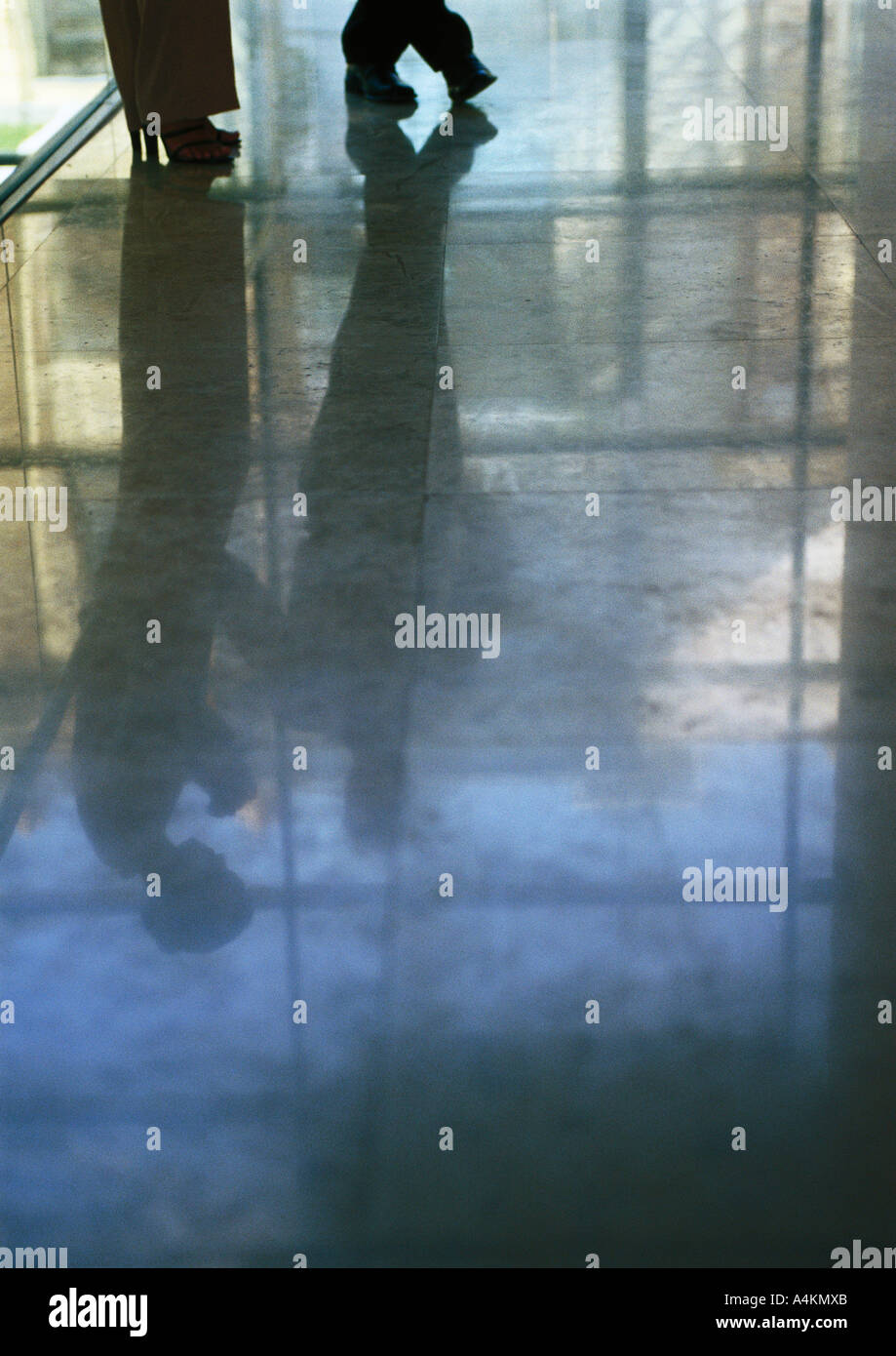 Feet of couple in conversation, reflection on shiny floor Stock Photo ...