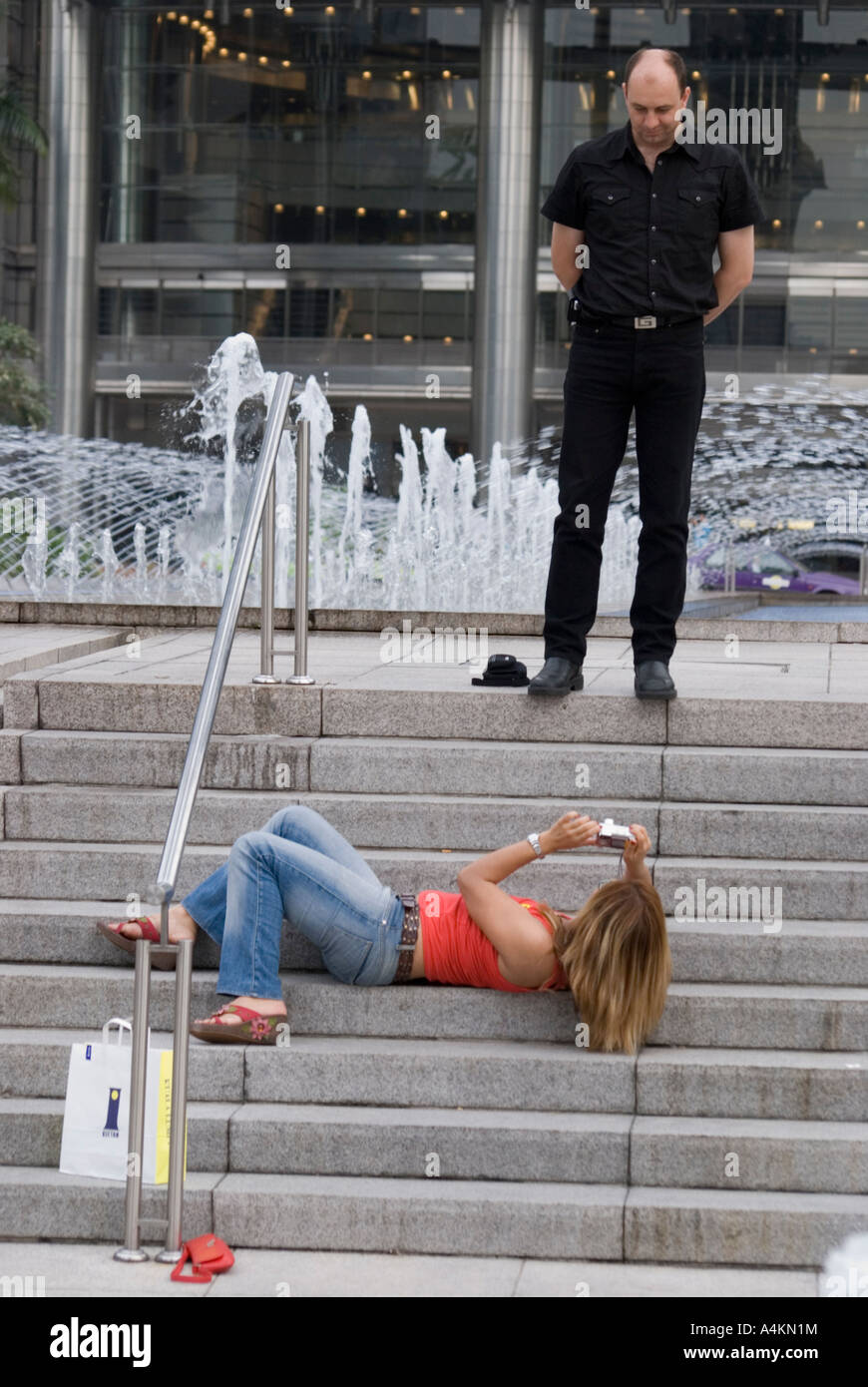 Woman taking photos from a reclining position with a digital camera ...