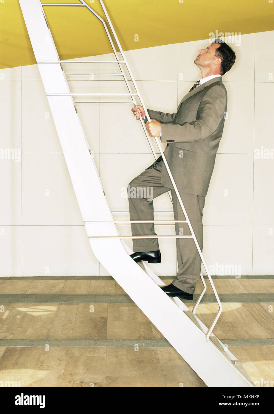 Man climbing ladder Stock Photo - Alamy
