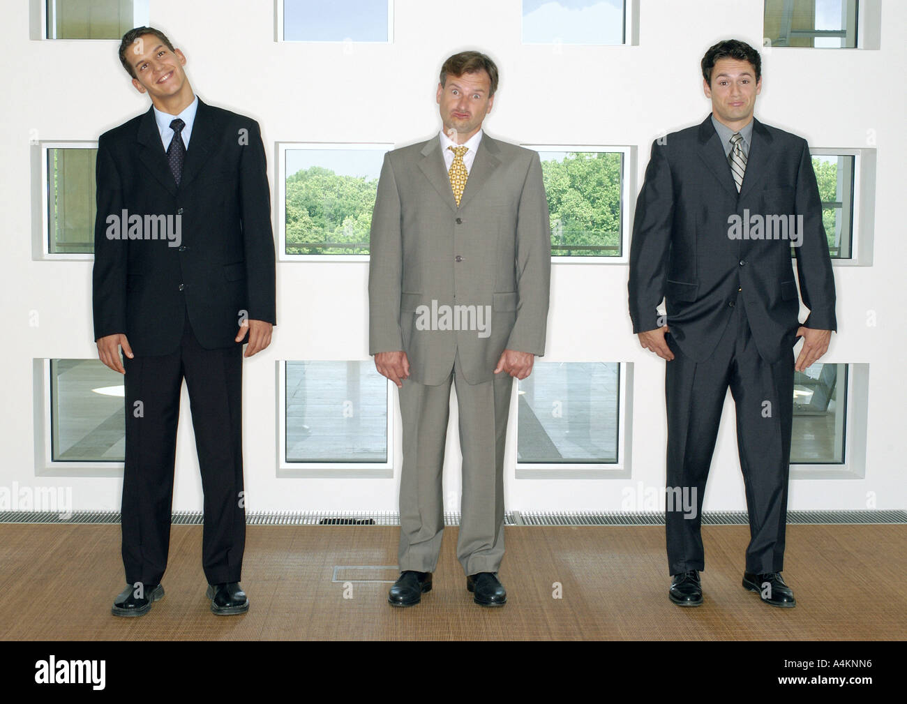 Three businessmen standing in a line Stock Photo - Alamy