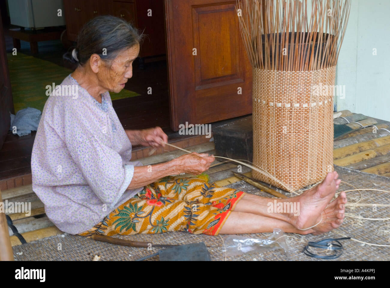 A Bidayuh woman weaving baskets at a long house at Annah Rais near the ...