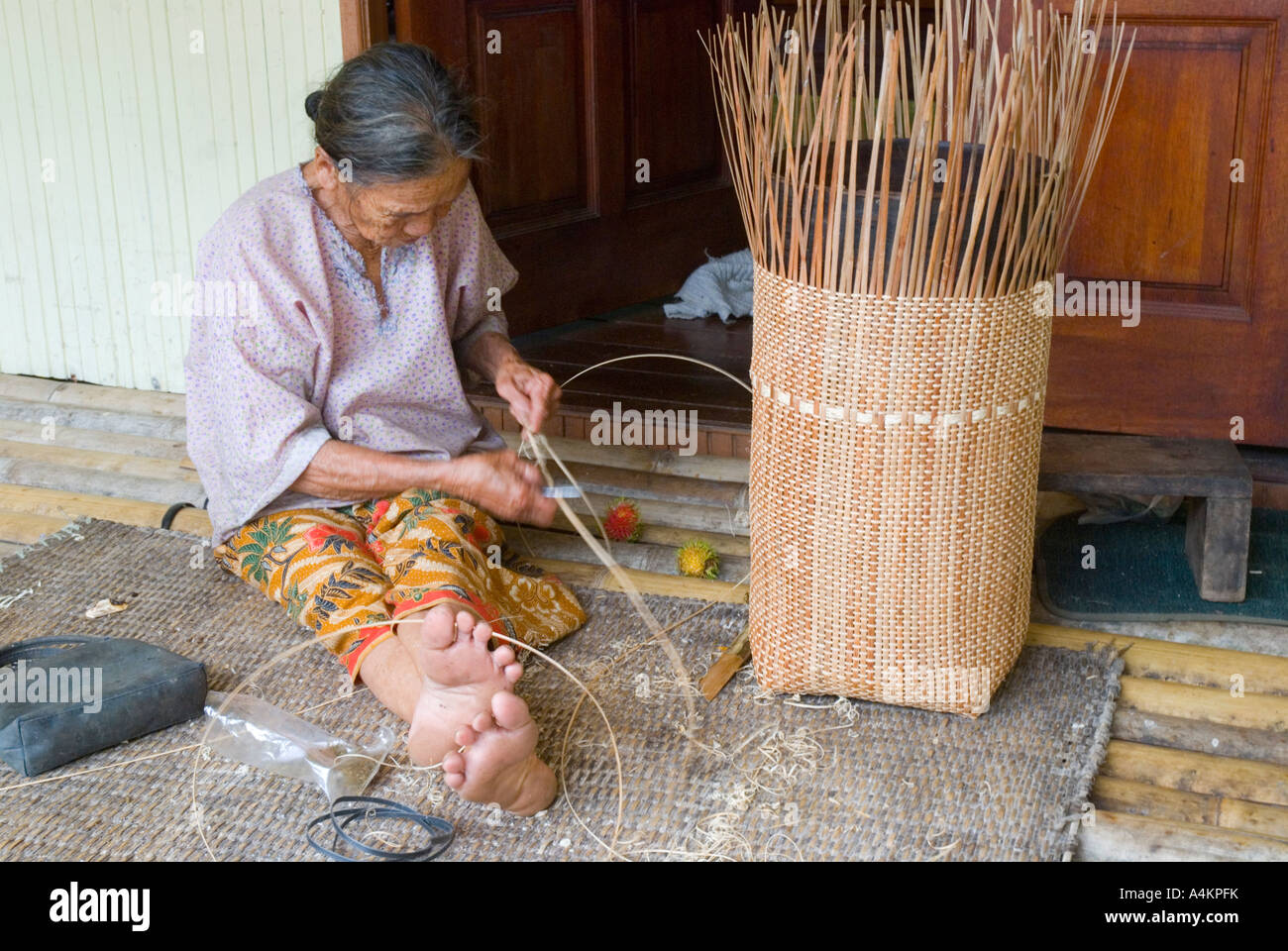 A Bidayuh woman weaving baskets at a long house at Annah Rais near the ...