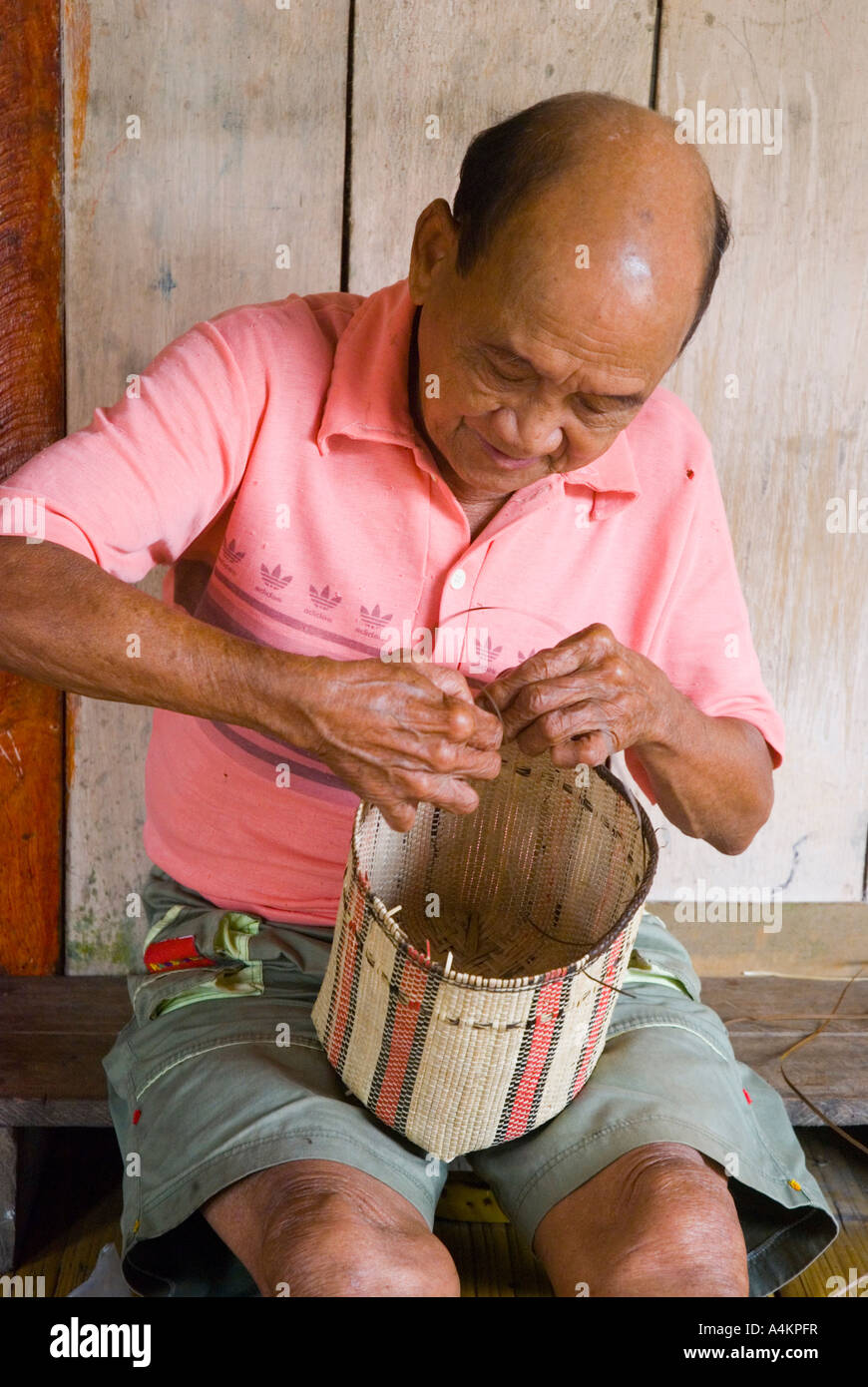 A Bidayuh man puts the finishing touches to a woven basket at a long ...