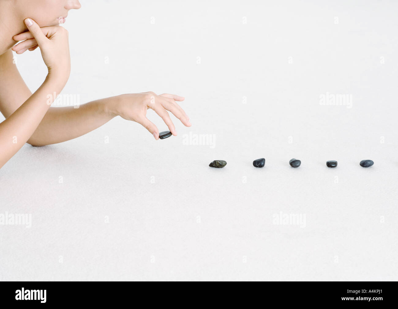 Woman placing stones in line Stock Photo - Alamy