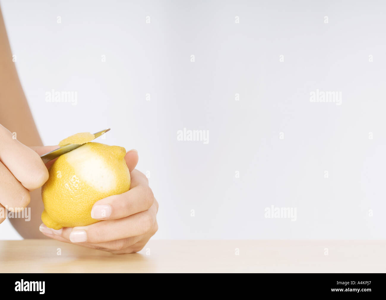 Woman's hands peeling lemon Stock Photo - Alamy