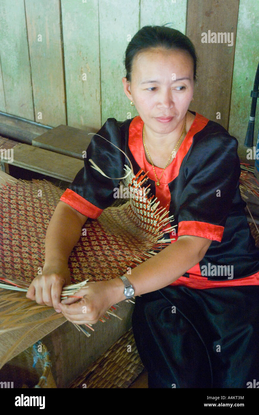 Bidayuh woman weaving a mat in a longhouse at the Sarawak Cultural ...
