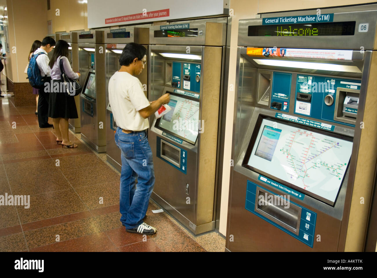 Passengers using the automatic ticketing machines for the Singapore ...