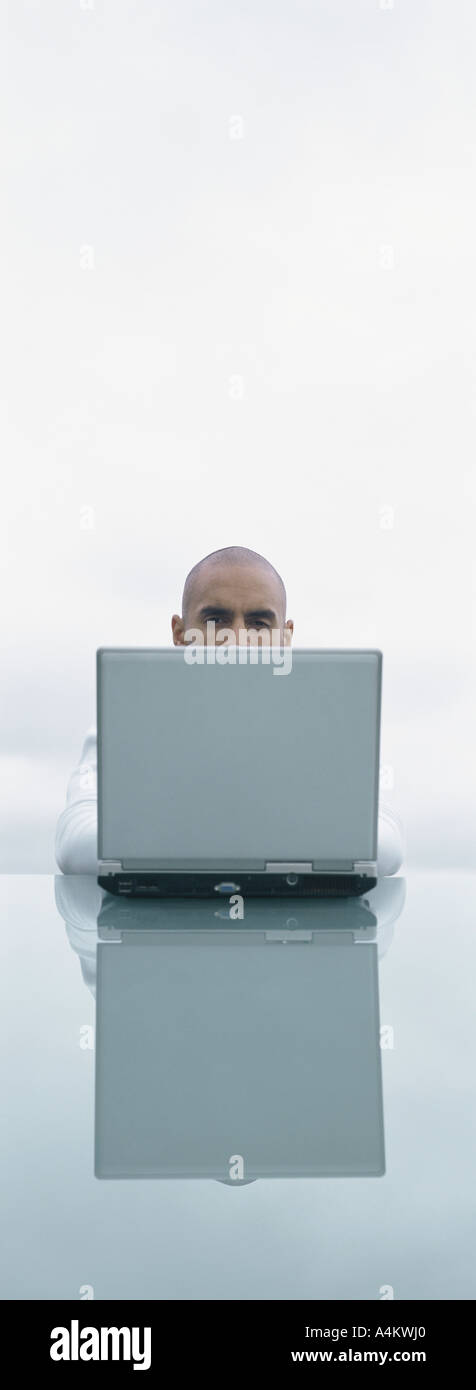 Top of man's head seen over back of laptop screen, outdoors Stock Photo ...