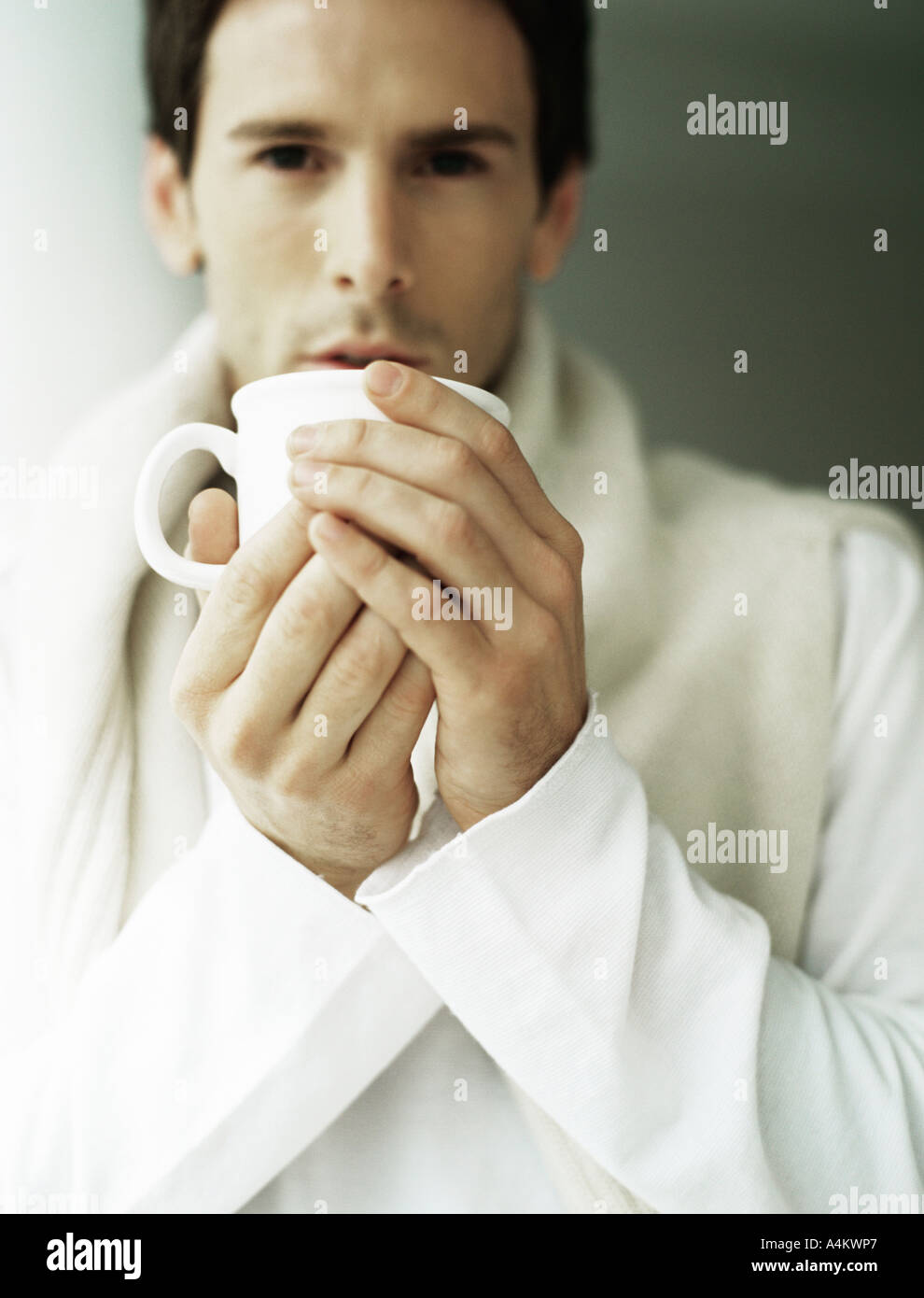 Man holding up mug with both hands Stock Photo - Alamy