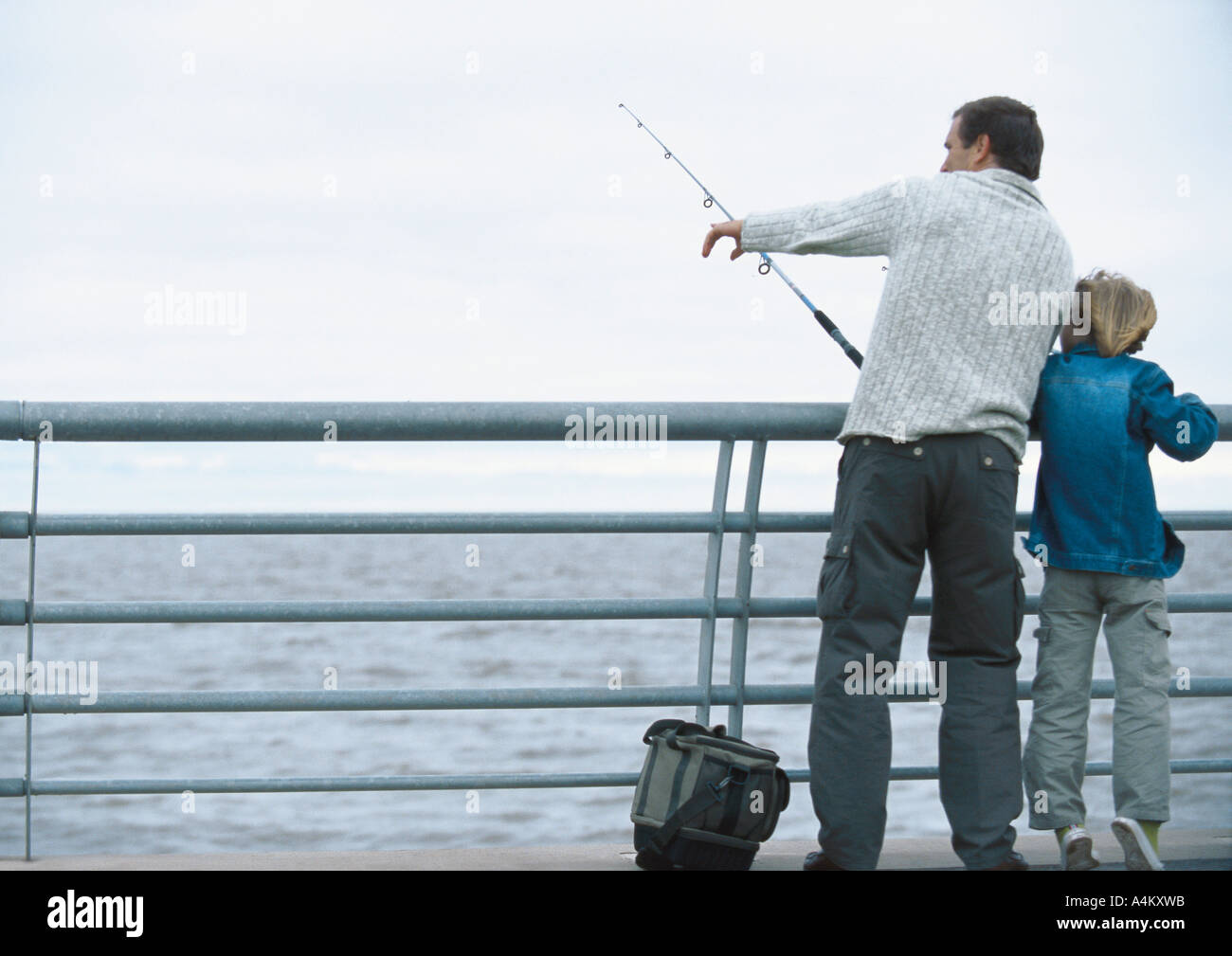 Man and son fishing on pier, man pointing, full length Stock Photo - Alamy