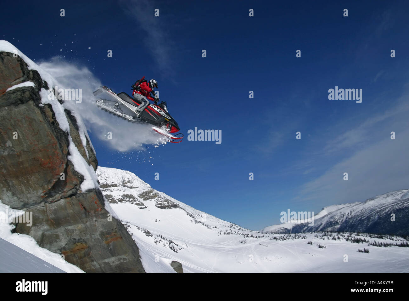 Snowmobile jumping off a cliff Stock Photo - Alamy
