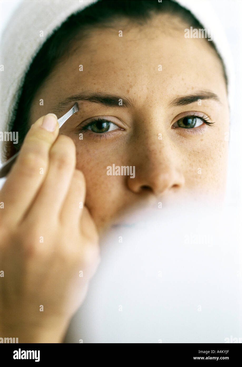 Young women tweezing eyebrows hi-res stock photography and images - Alamy