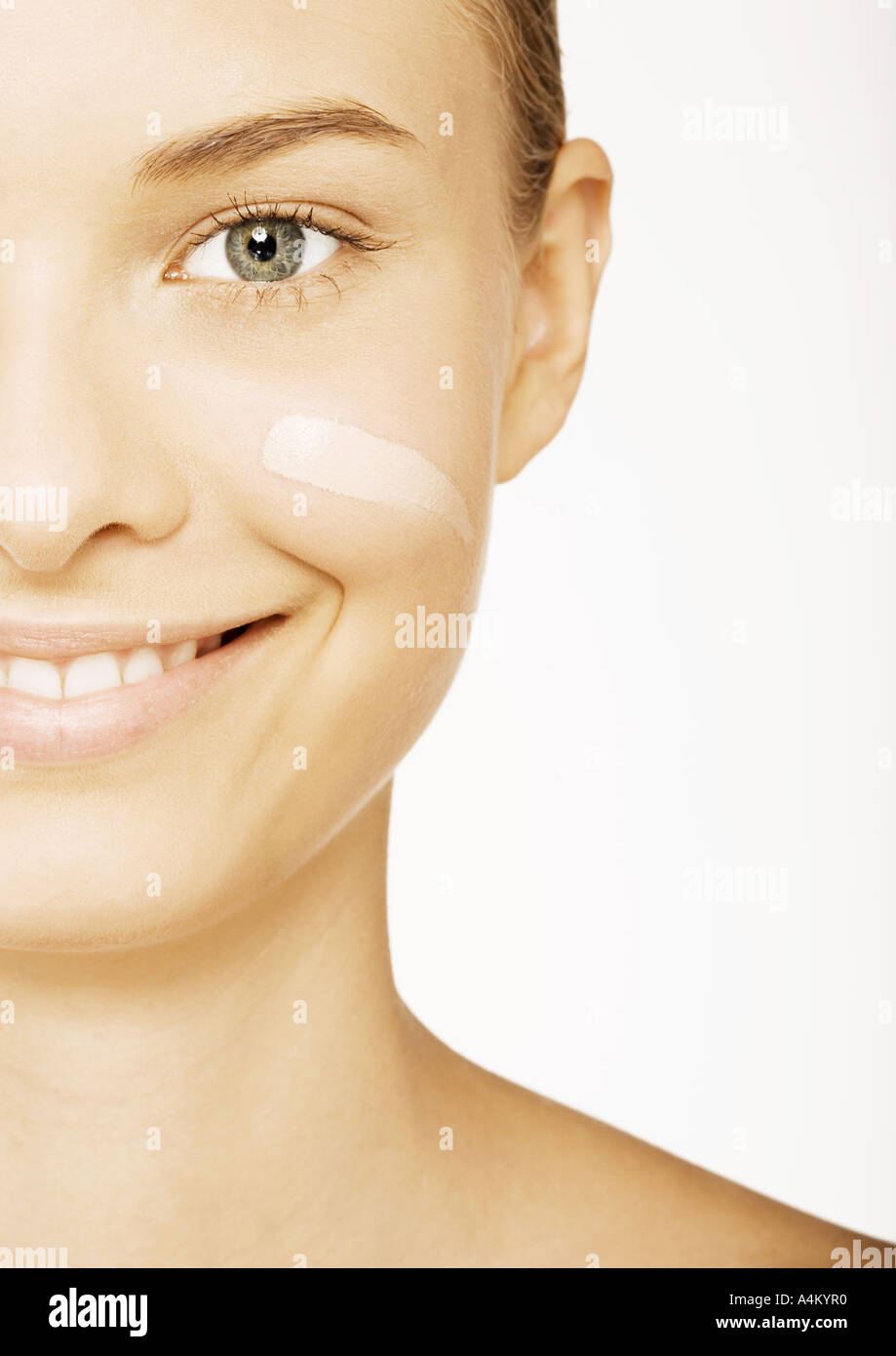 Woman's face with foundation on cheek, partial view Stock Photo - Alamy