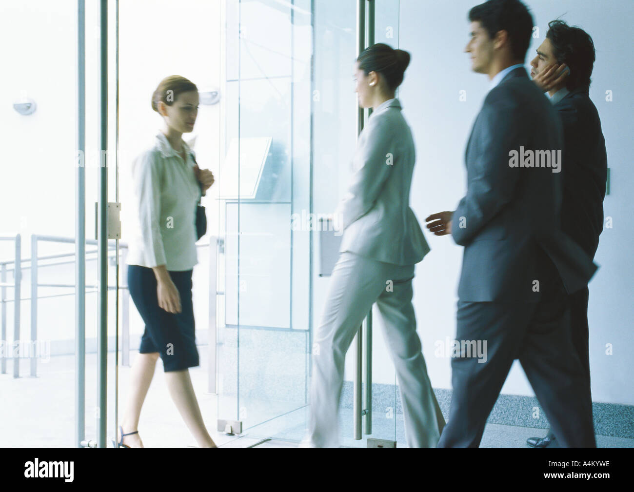 Businesspeople entering and exiting through glass doors Stock Photo - Alamy