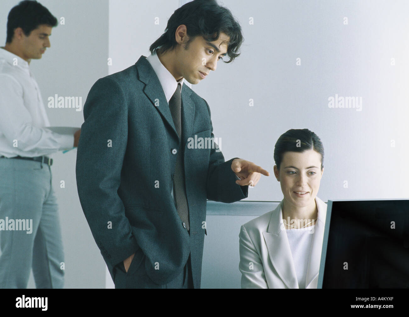 Two colleagues looking at computer, man pointing Stock Photo - Alamy