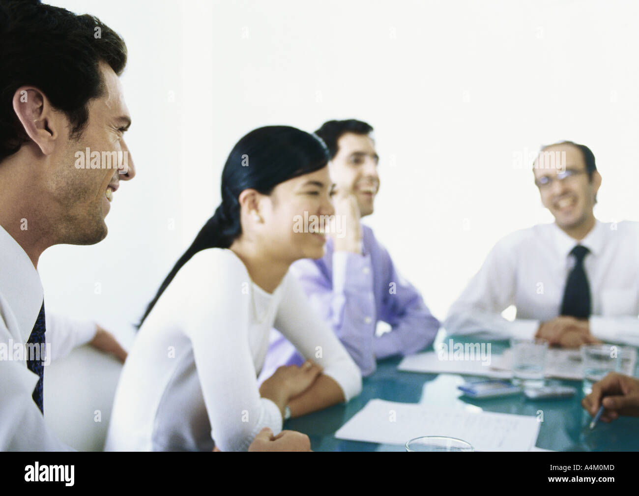 Businesspeople sitting around table together, laughing Stock Photo - Alamy