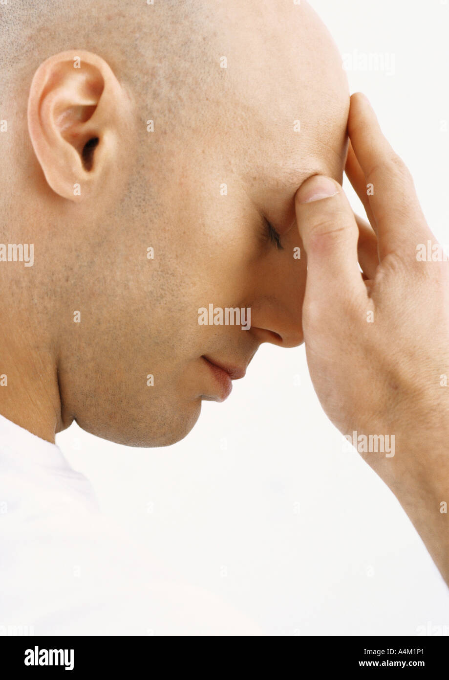 Man touching forehead, close-up, side view Stock Photo - Alamy