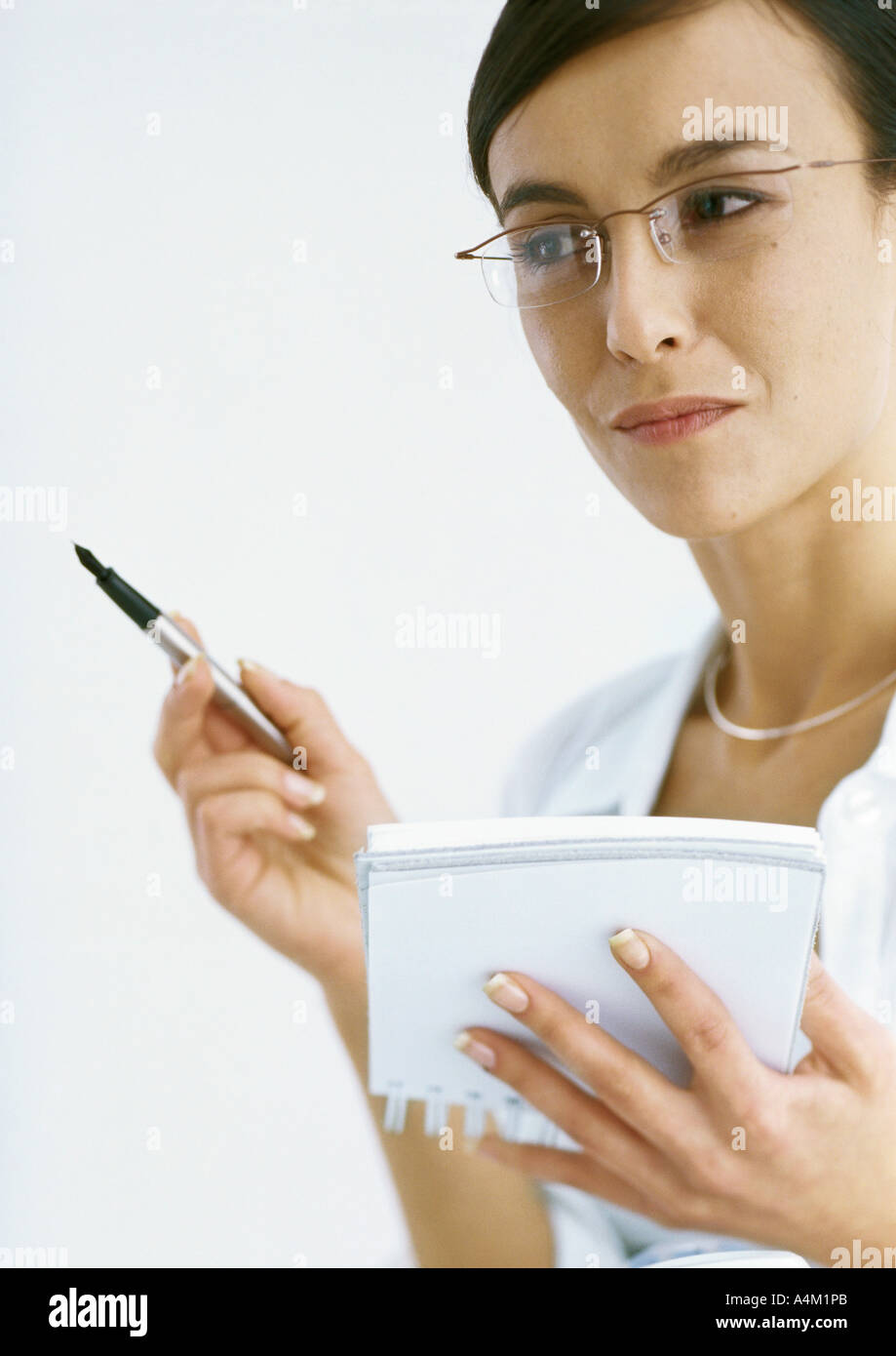 Woman holding notepad and pen Stock Photo - Alamy