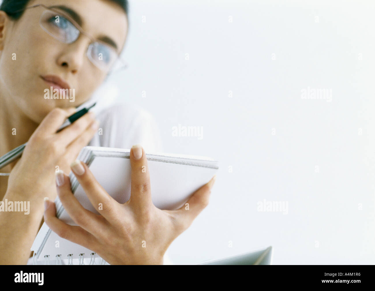 Woman on phone holding notepad and pen Stock Photo - Alamy
