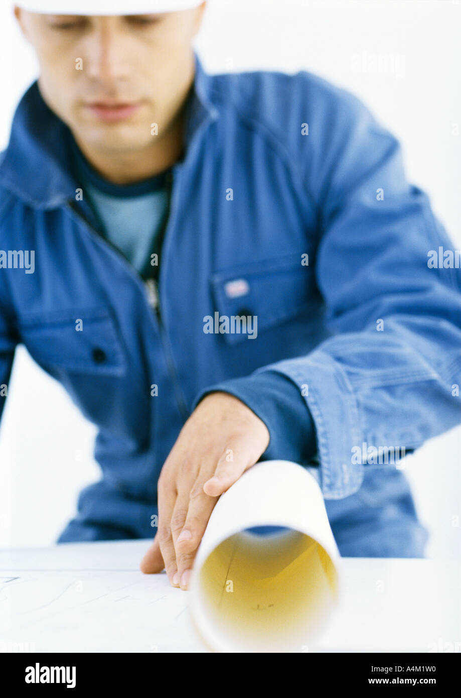 Man in coveralls looking at blueprints Stock Photo - Alamy