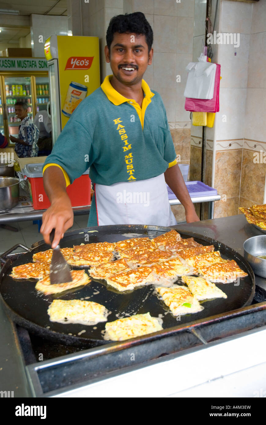 An Indian cook frying martabak pancakes on Lebuh Chulia Georgetown ...