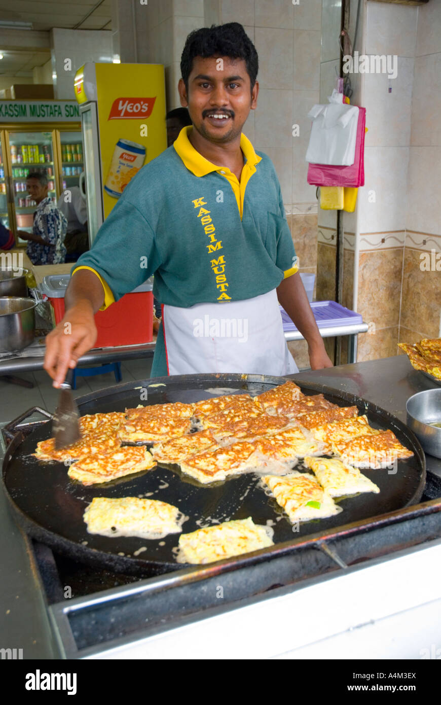 An Indian cook frying martabak pancakes on Lebuh Chulia Georgetown ...