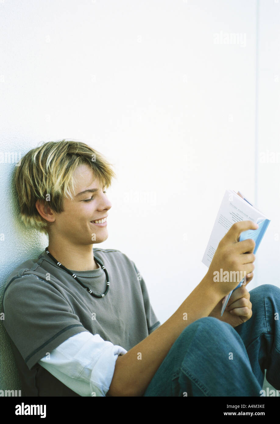 Teenage boy reading book Stock Photo - Alamy