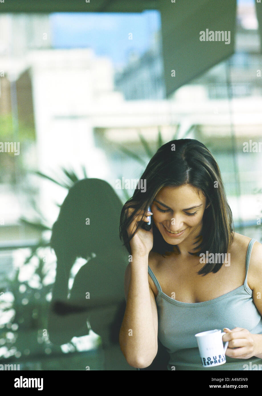 Woman talking on cell phone, holding coffee cup Stock Photo - Alamy