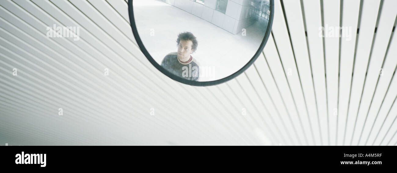 Young man's reflection in mirror Stock Photo - Alamy