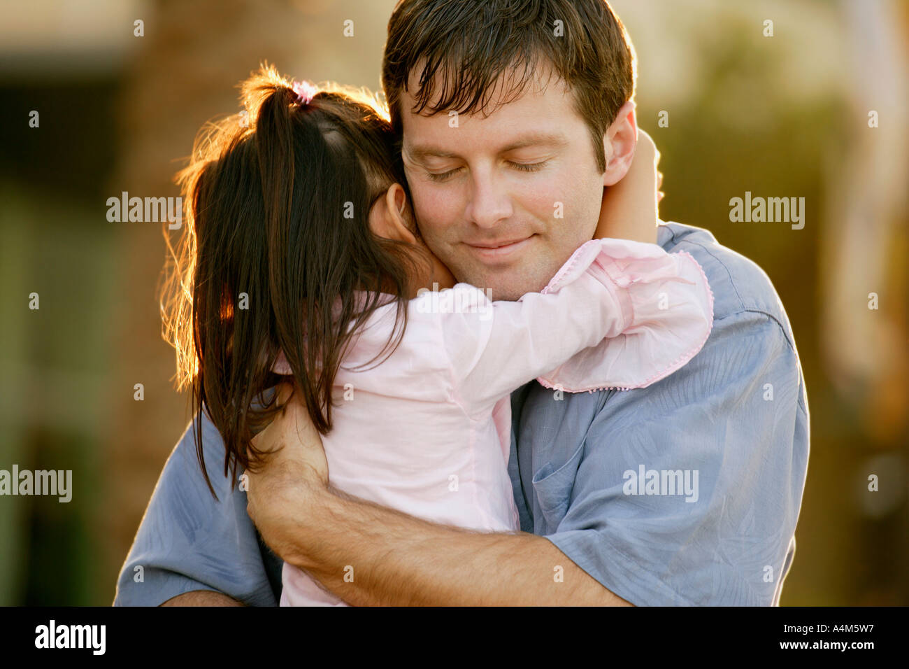Girl hugging father Stock Photo - Alamy