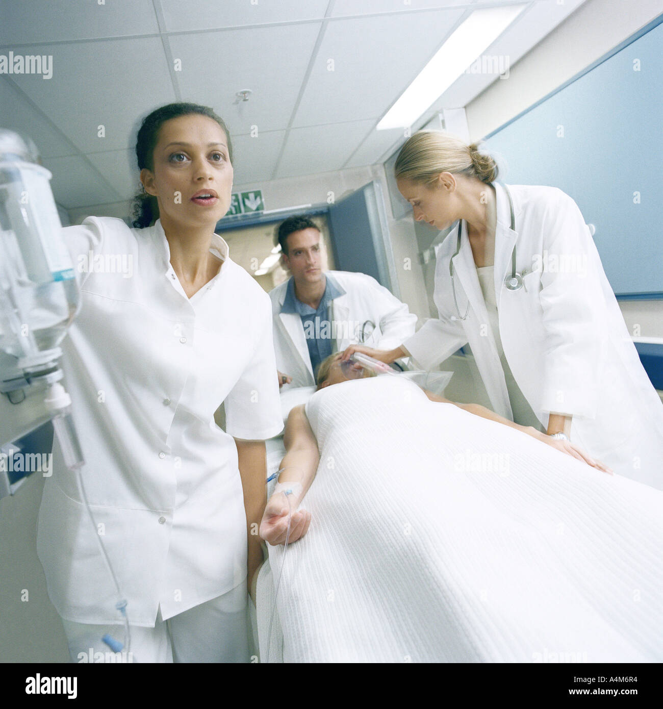 Medical team transporting patient on gurney Stock Photo - Alamy