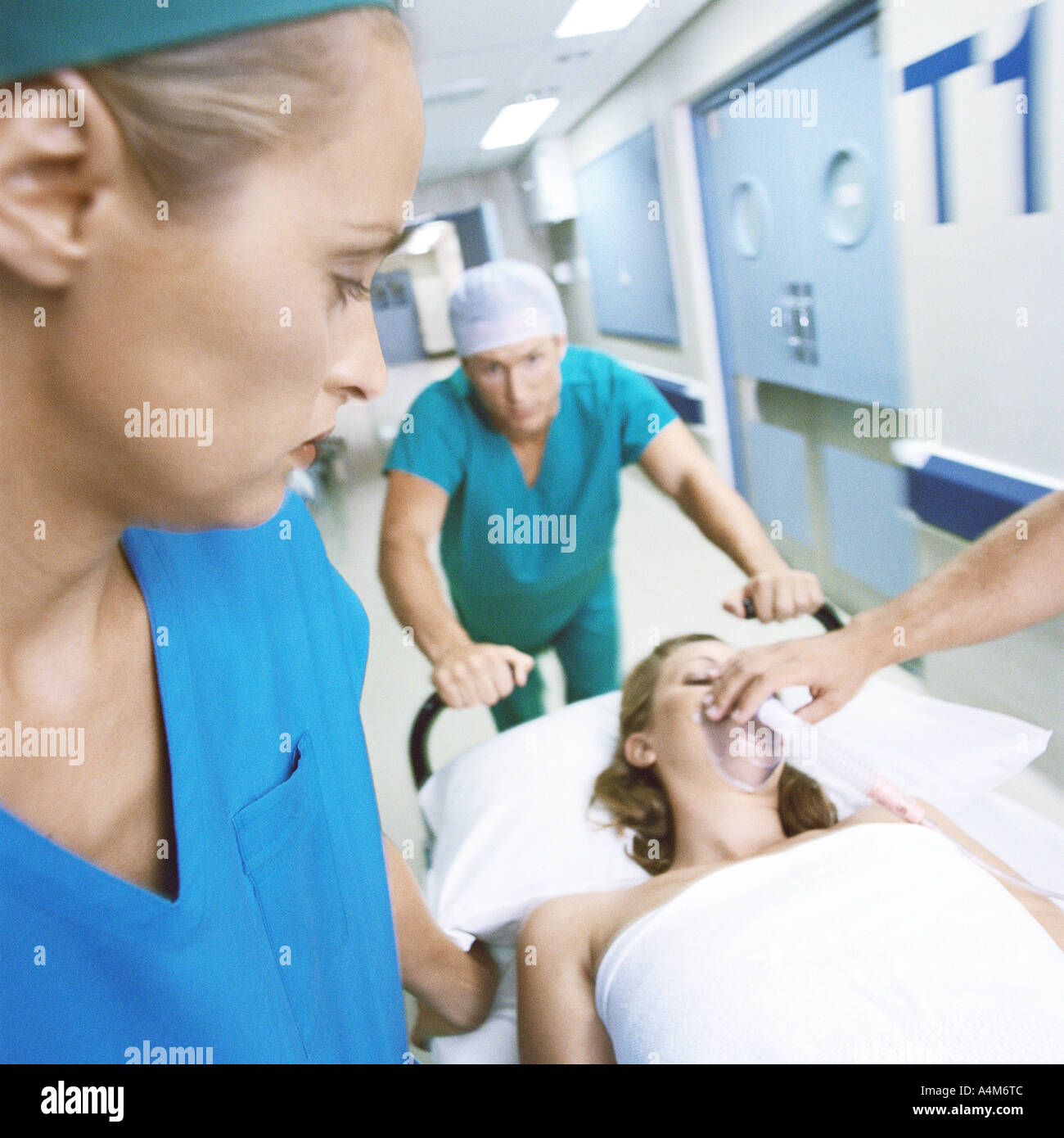 Medical team moving patient on gurney Stock Photo - Alamy