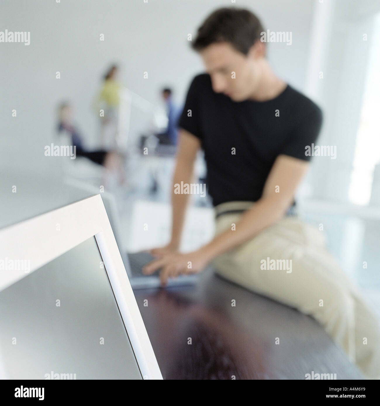 Woman sitting on edge desk hi-res stock photography and images - Alamy