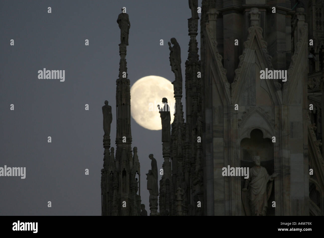 Statue Figure praying backlit by the moon Stock Photo - Alamy