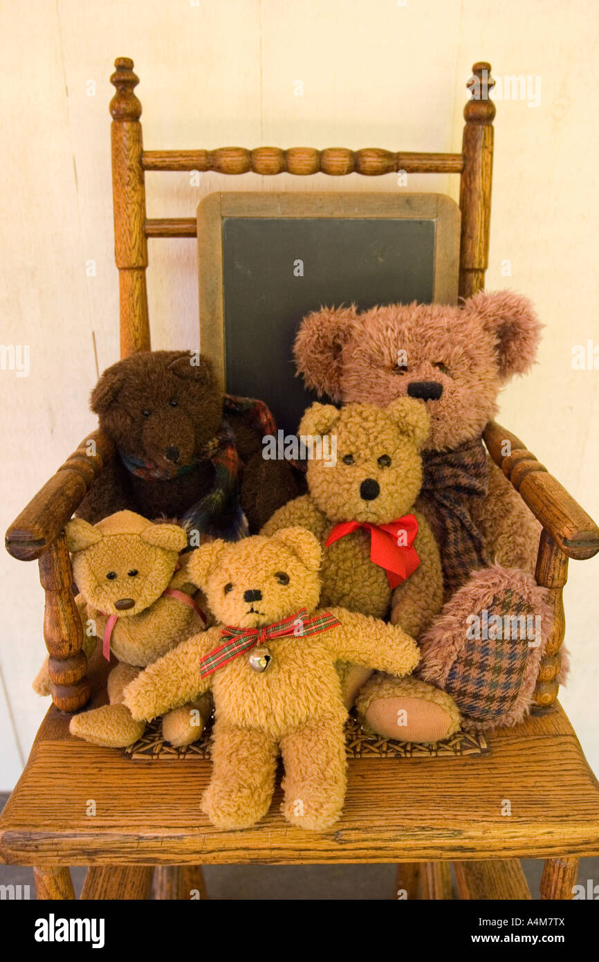 A collection of beloved teddy bears sitting in an antique chair Stock ...