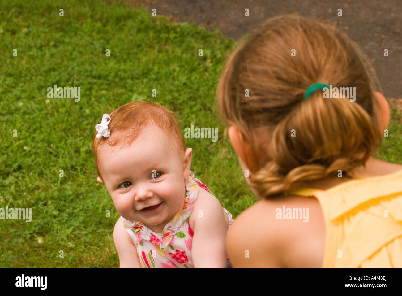 Two sisters playing outdoors in the summer sunshine Stock Photo - Alamy